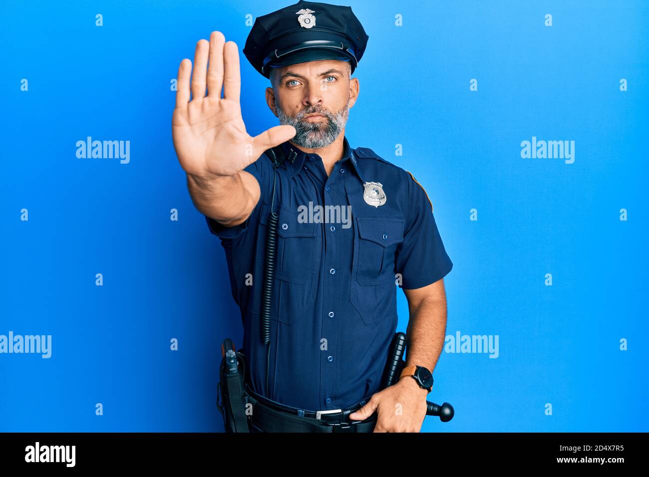 Middle age handsome man wearing police uniform doing stop sing with ...