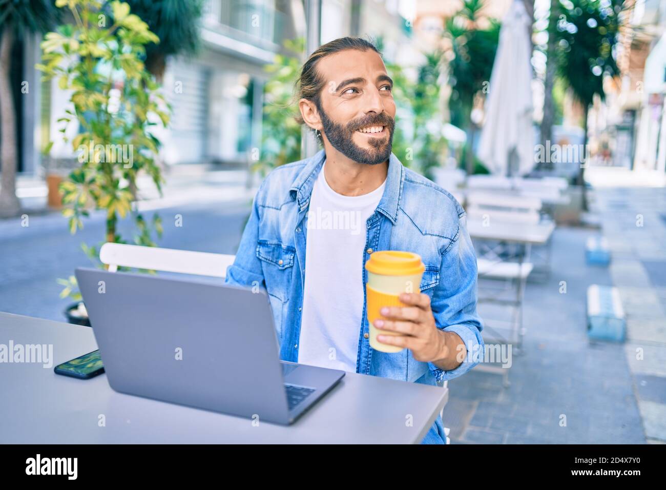 Young middle eastern man smiling happy working using laptop at coffee ...