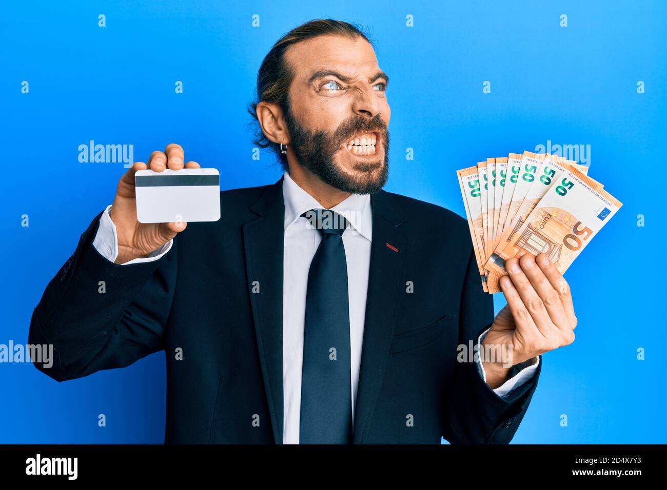 Attractive business man with long hair and beard holding credit card ...