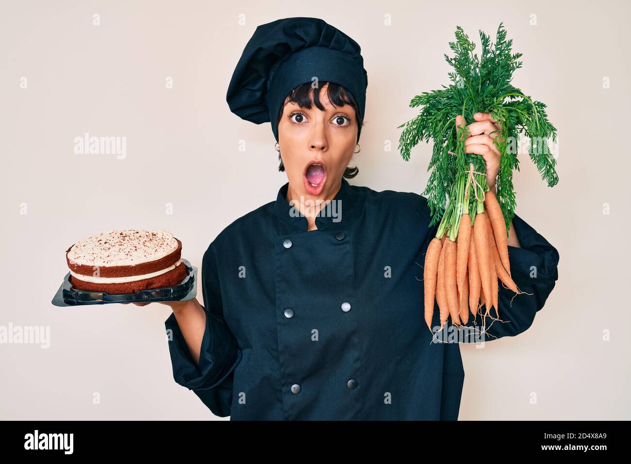 Beautiful brunettte woman chef cooking carrot cake afraid and shocked ...