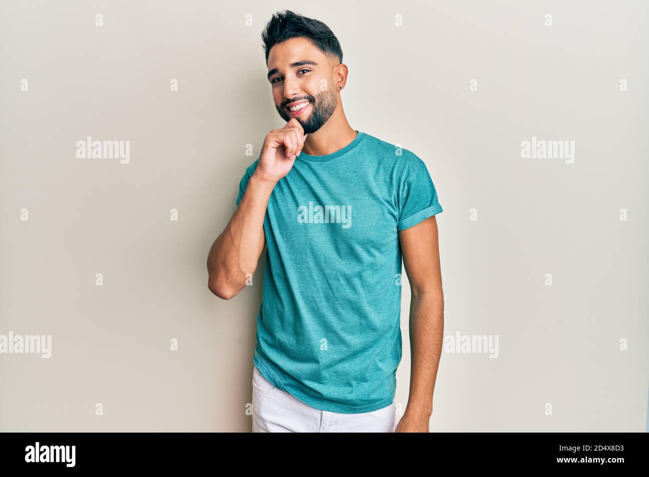Young man with beard wearing casual clothes smiling looking confident ...