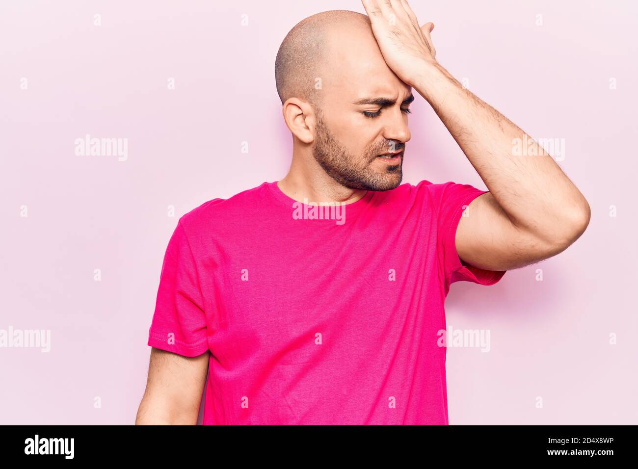 Young handsome bald man wearing casual t shirt surprised with hand on ...