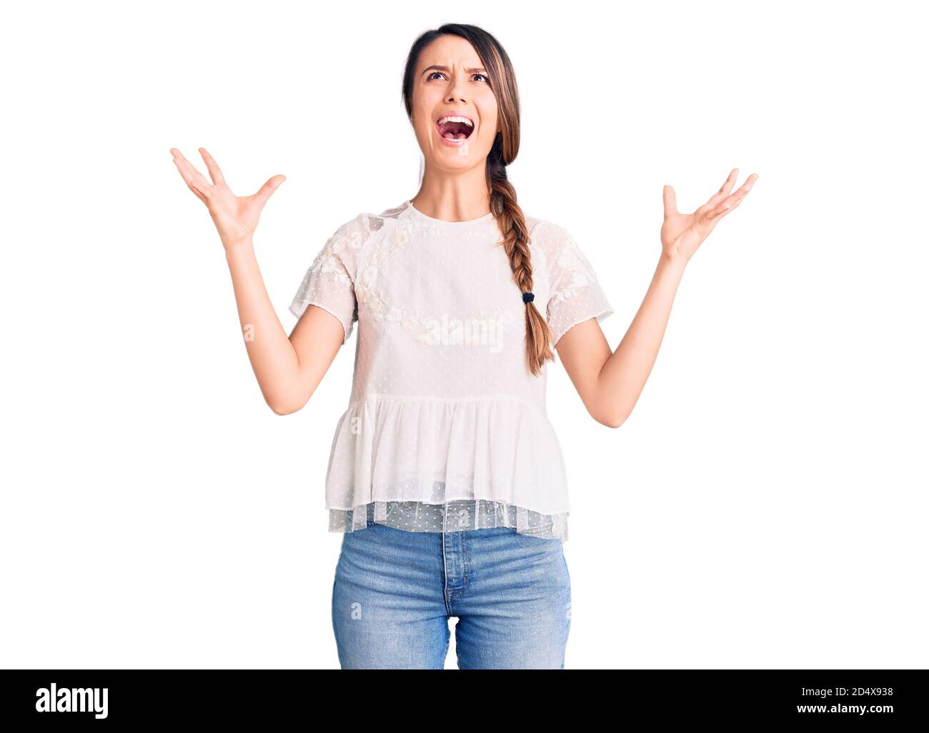 Young beautiful girl wearing casual t shirt crazy and mad shouting and ...