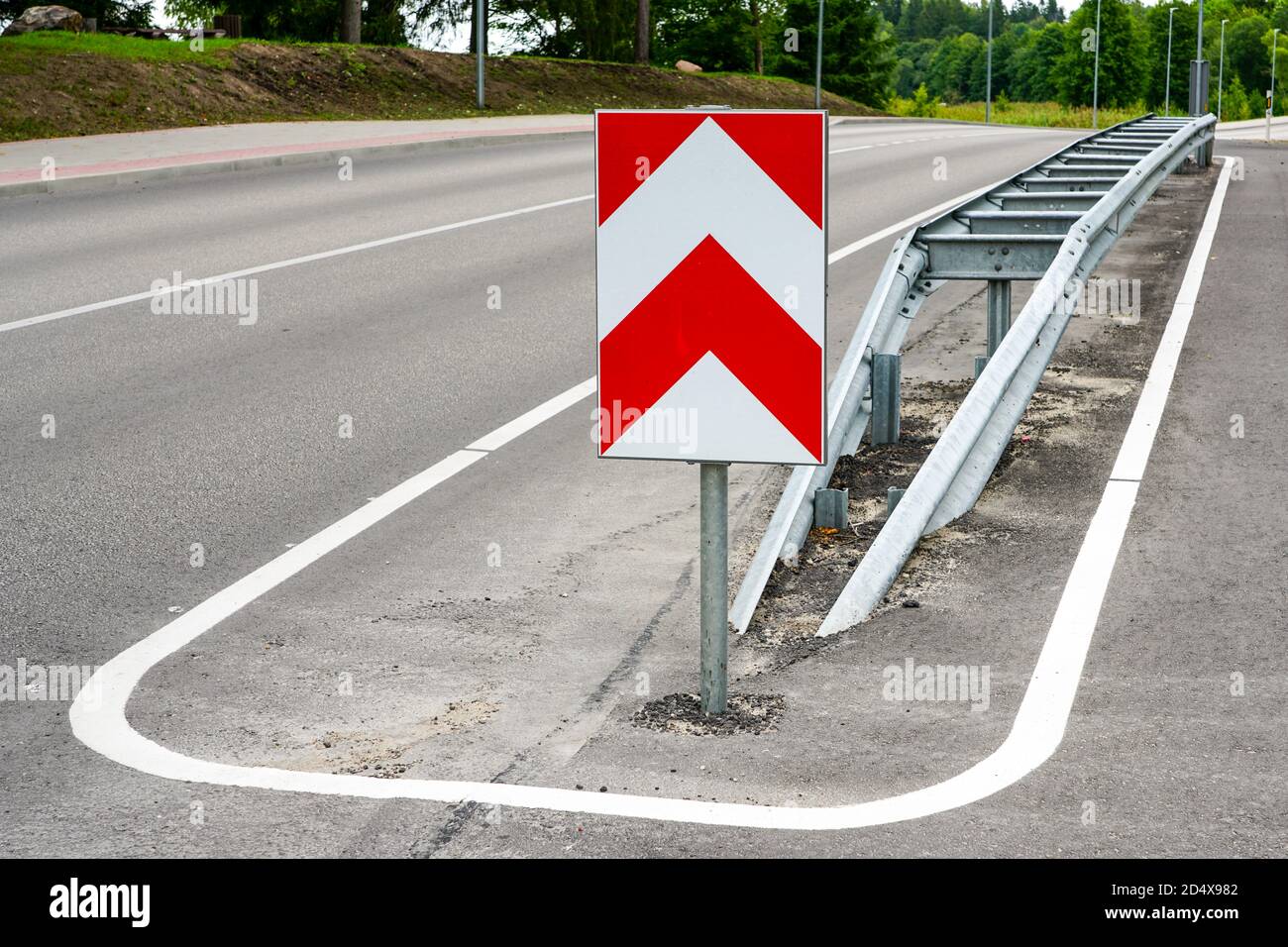a metal safety barrier with a red and white striped traffic sign at the ...