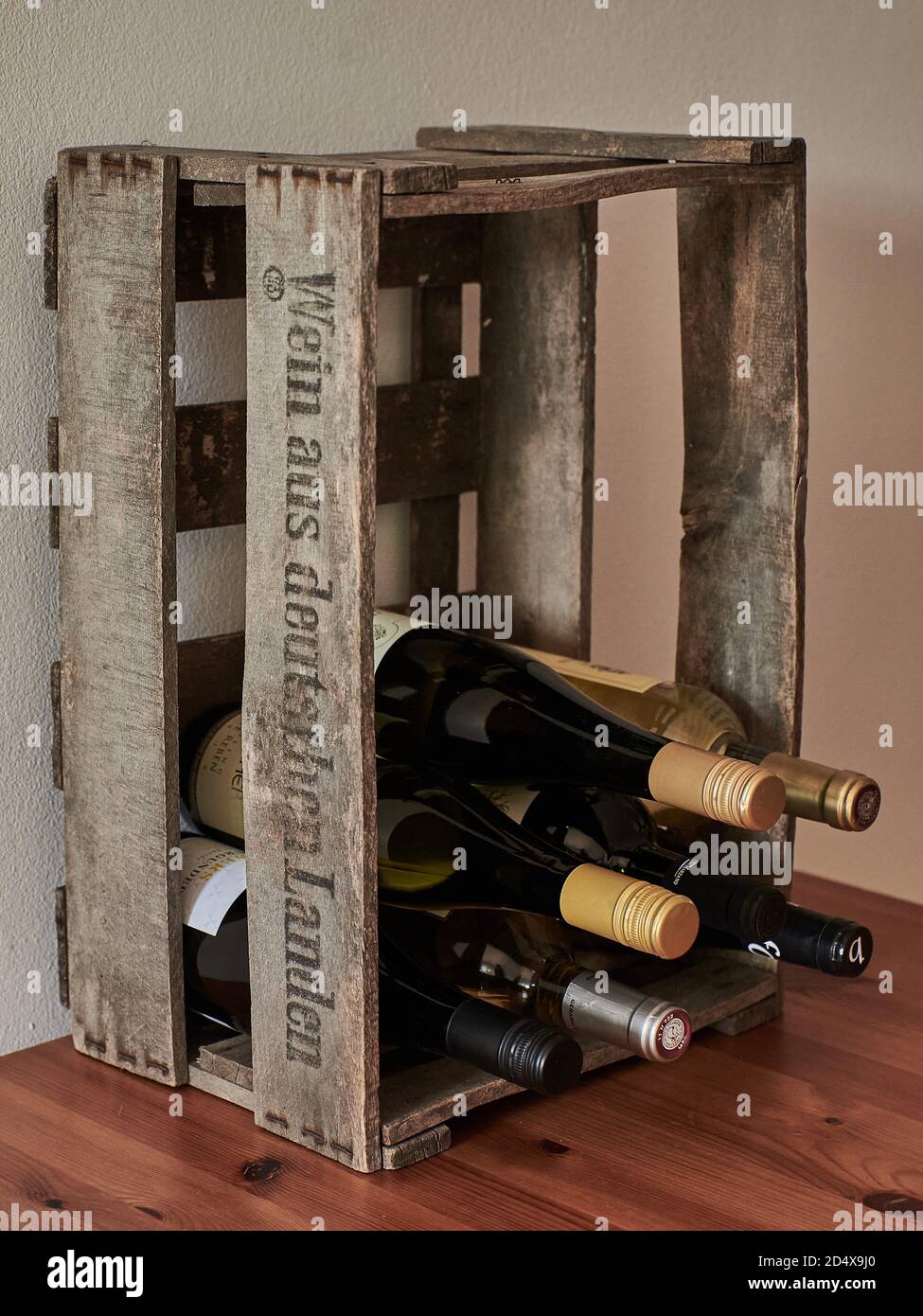 Wine bottles stacked in a vintage wine box. Closeup of an antique case ...