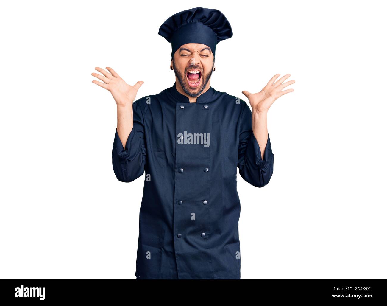 Young hispanic man wearing cooker uniform celebrating mad and crazy for ...