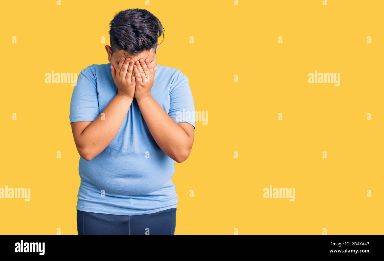 Little boy kid wearing sports workout clothes with sad expression ...