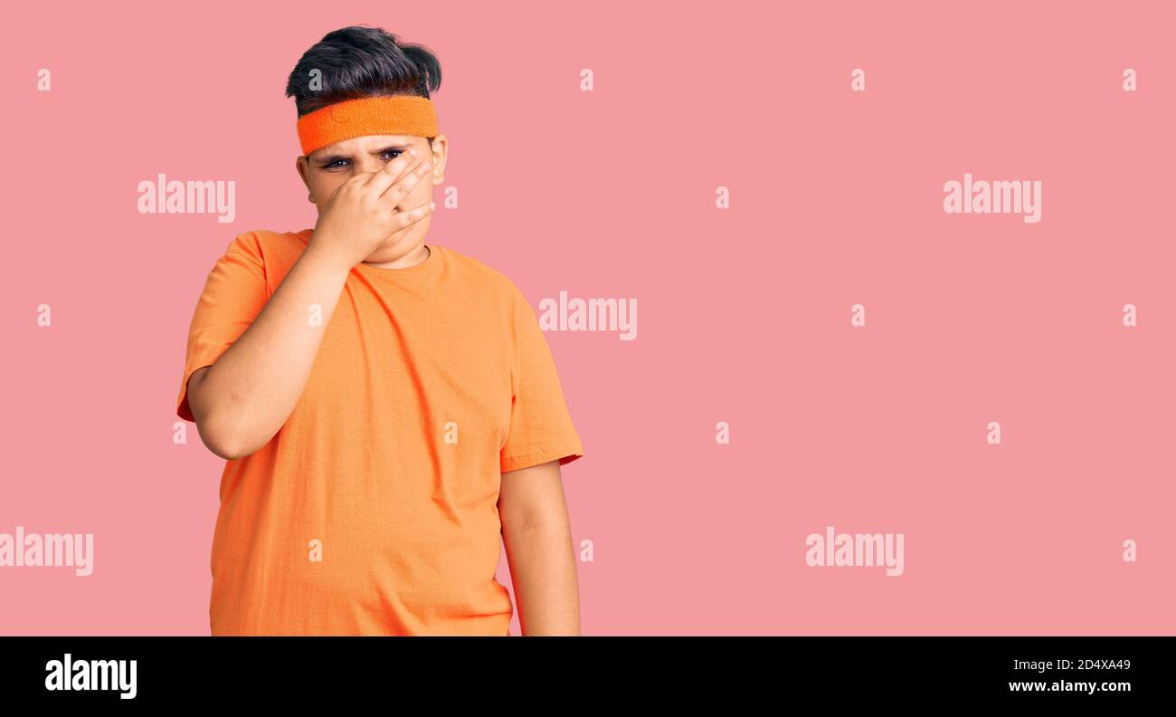 Little boy kid wearing sportswear smelling something stinky and ...