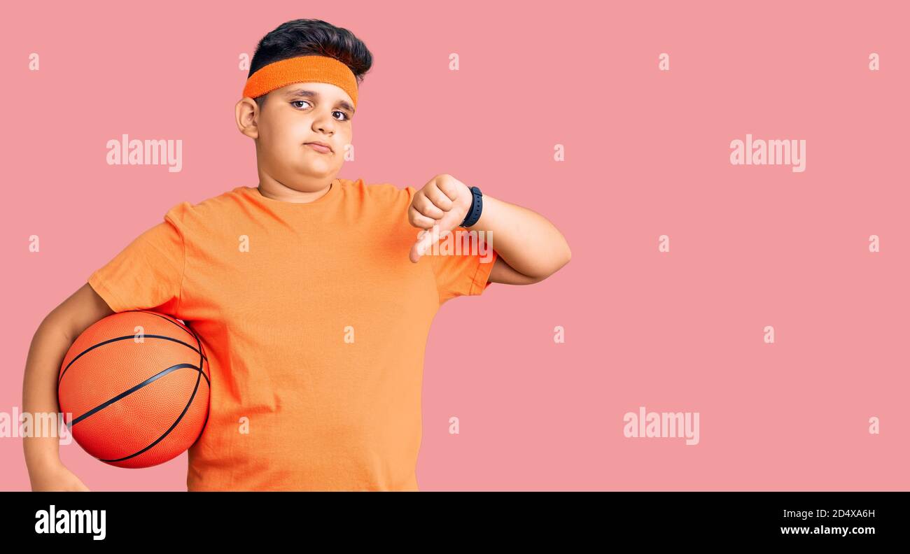 Little boy kid holding basketball ball with angry face, negative sign ...