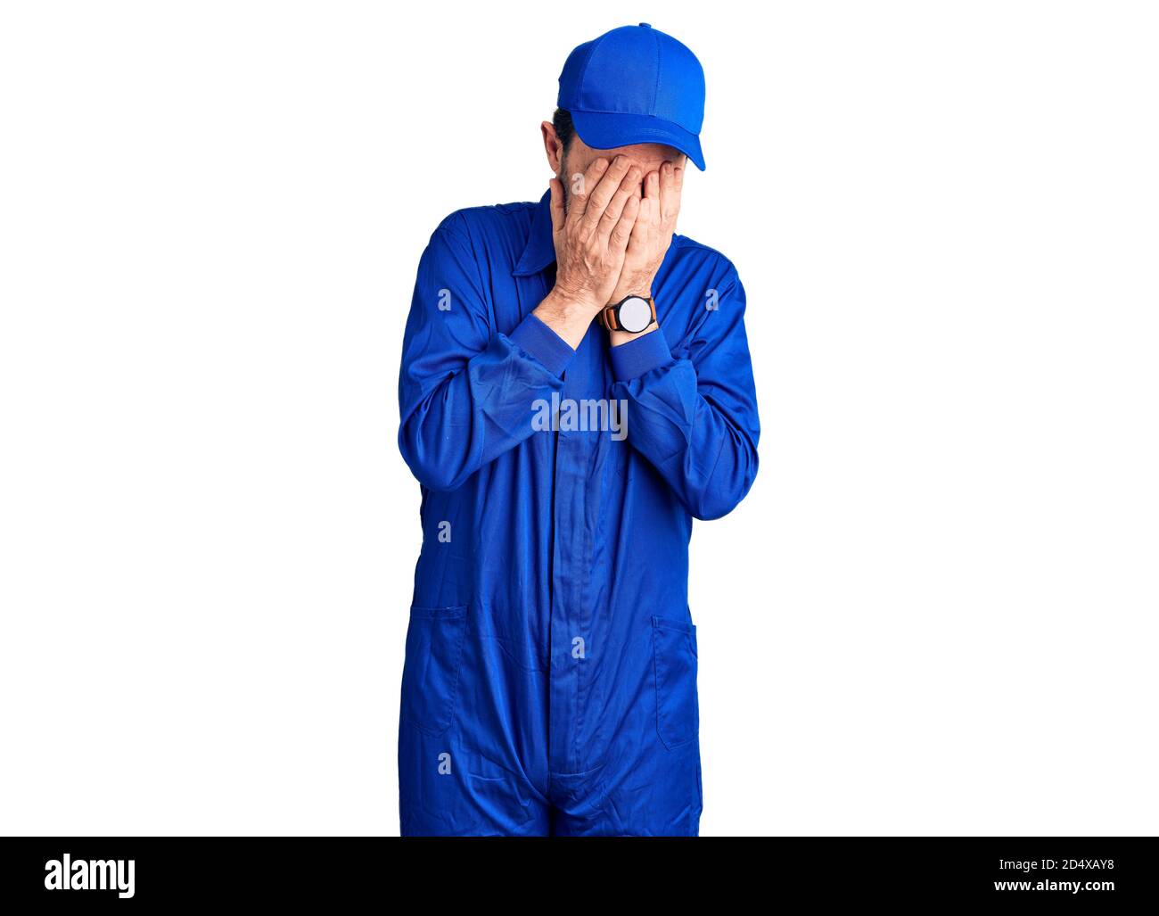 Middle age handsome man wearing mechanic uniform with sad expression ...