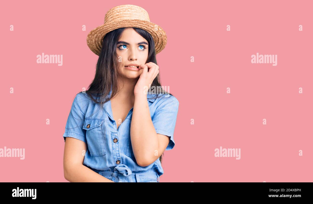 Brunette teenager girl wearing summer hat looking stressed and nervous ...