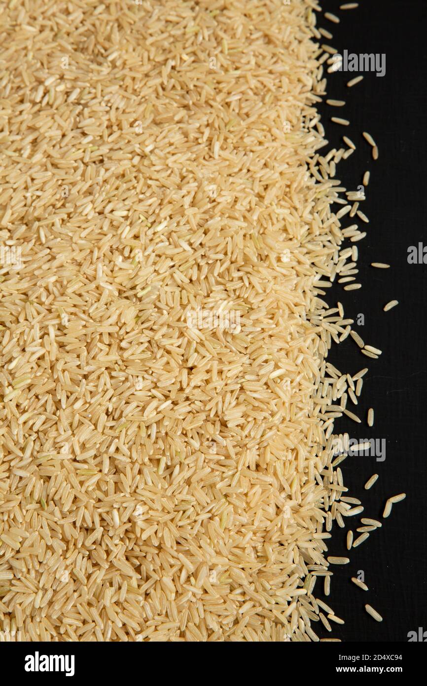 Dry Brown Rice on a black background, side view Stock Photo - Alamy