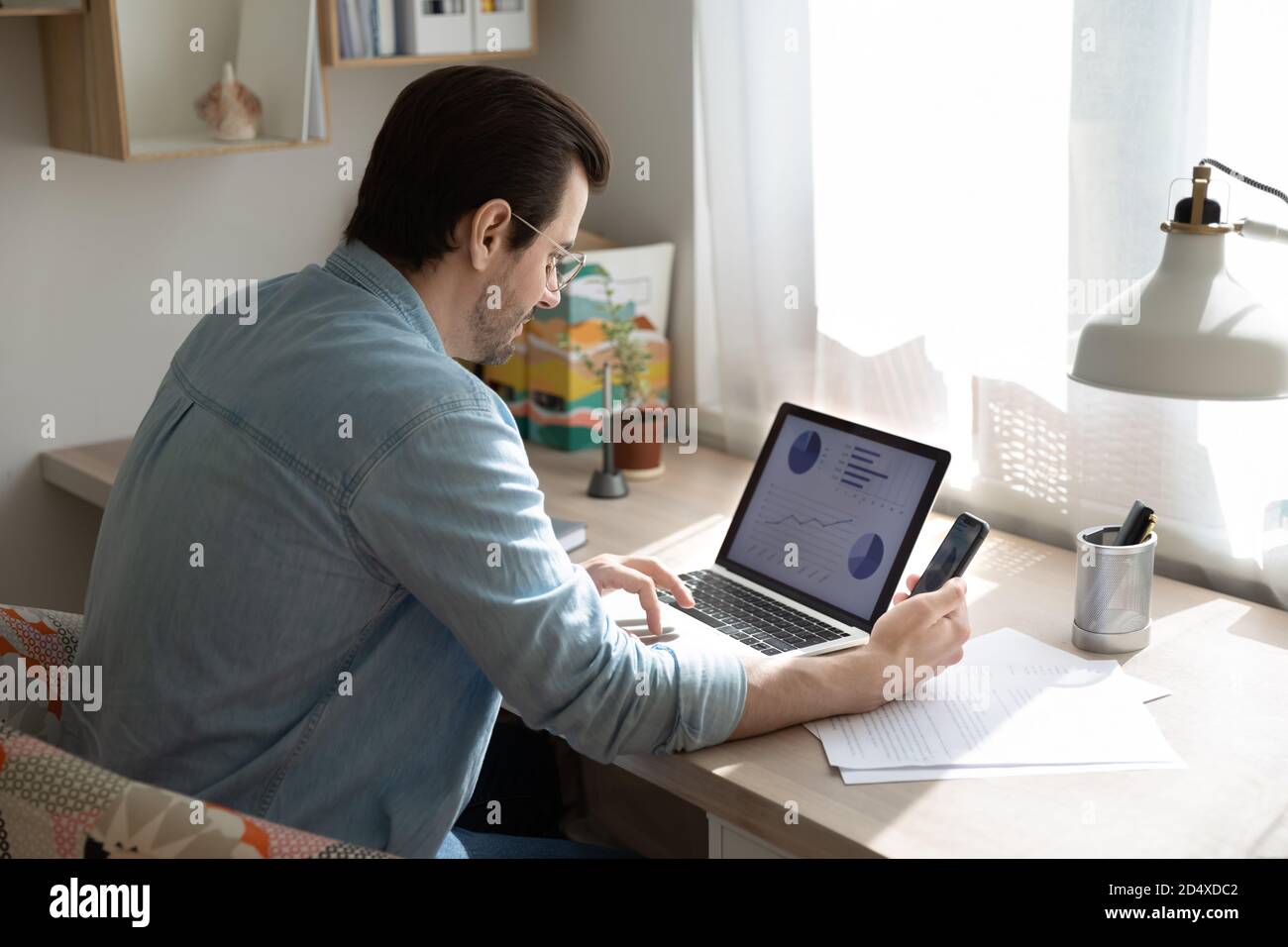 Concentrated young businessman analyzing marketing research graphs ... Concentrated young businessman analyzing marketing research graphs ...
