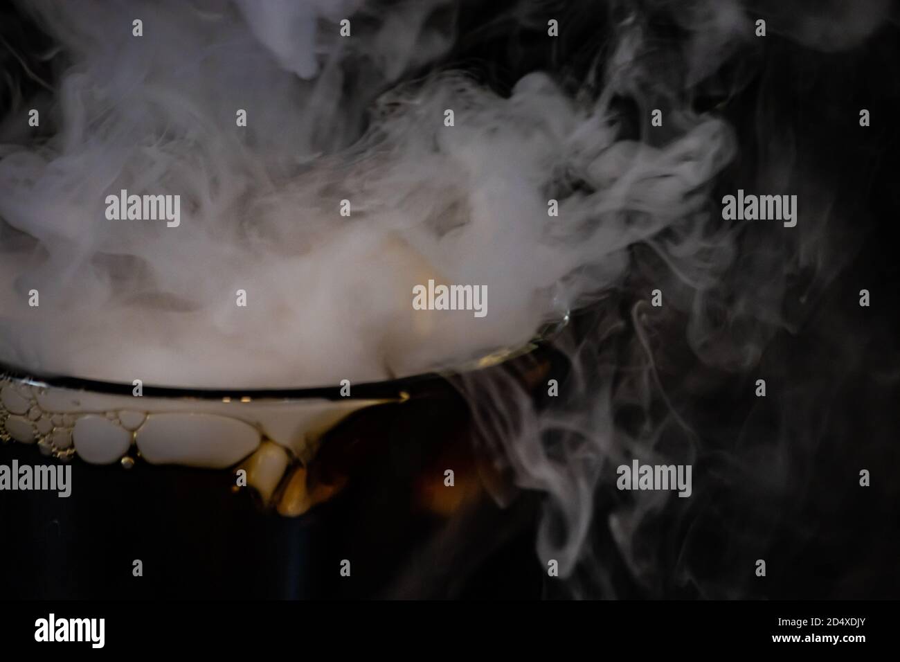 various glasses and dishes with water and dry ice smoking and bubbling ...