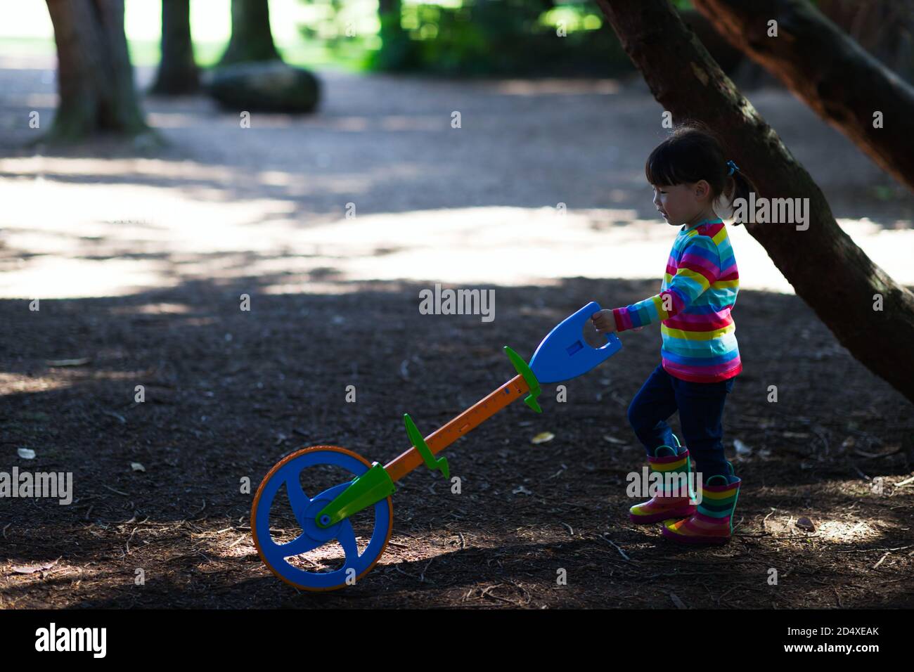 young girl playing outdoor measure-mate in the forest park for leaning ...