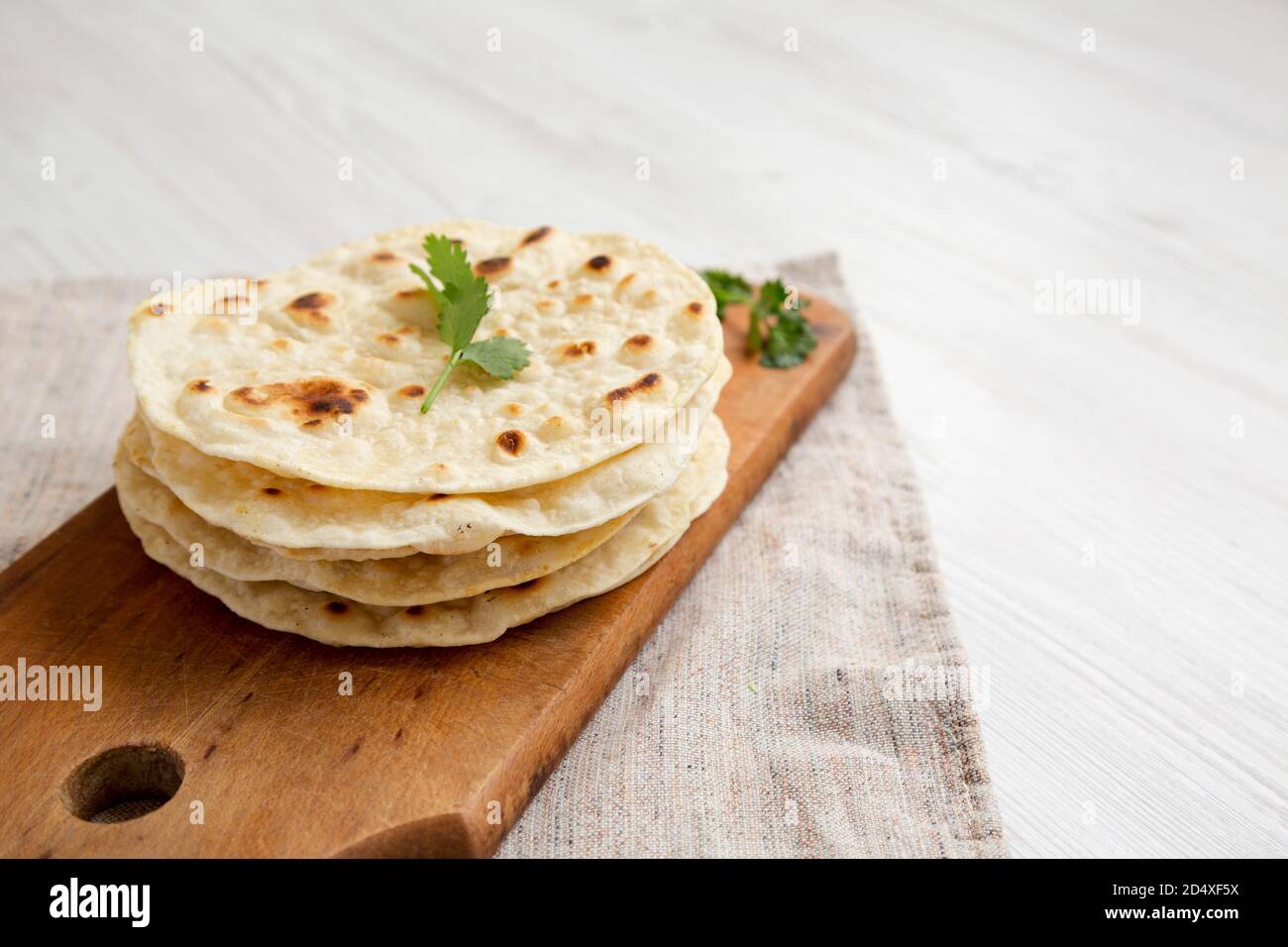 Homemade Roti Chapati Flatbread on a rustic wooden board on a white ...
