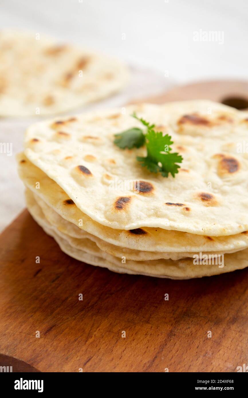 Homemade Roti Chapati Flatbread on a rustic wooden board on a white ...