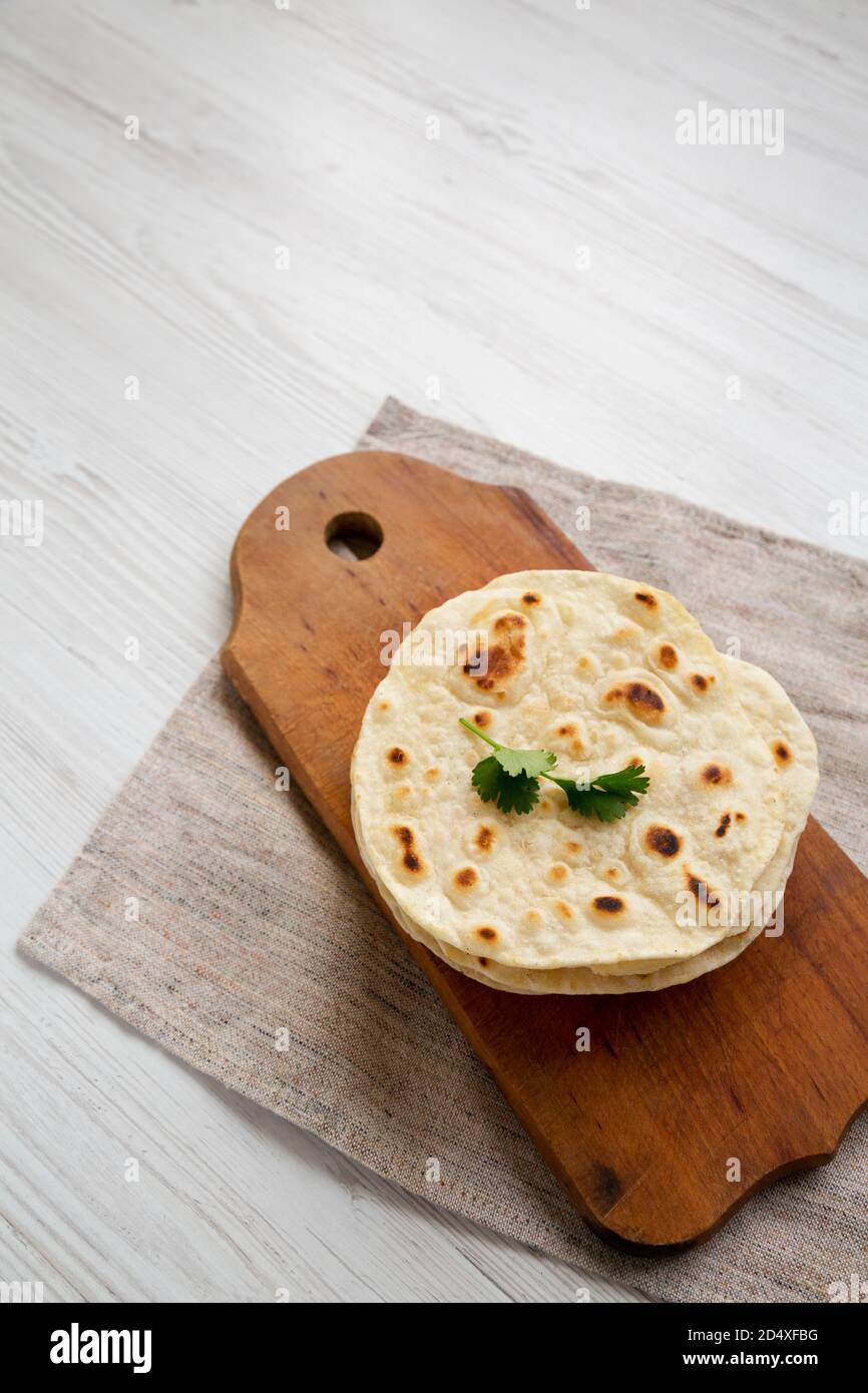 Homemade Roti Chapati Flatbread on a rustic wooden board on a white ...