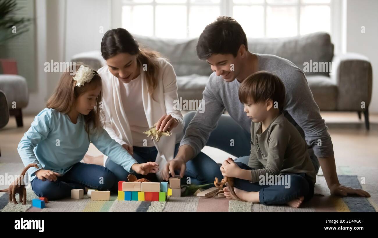 Happy parents and small kids playing at home Stock Photo - Alamy