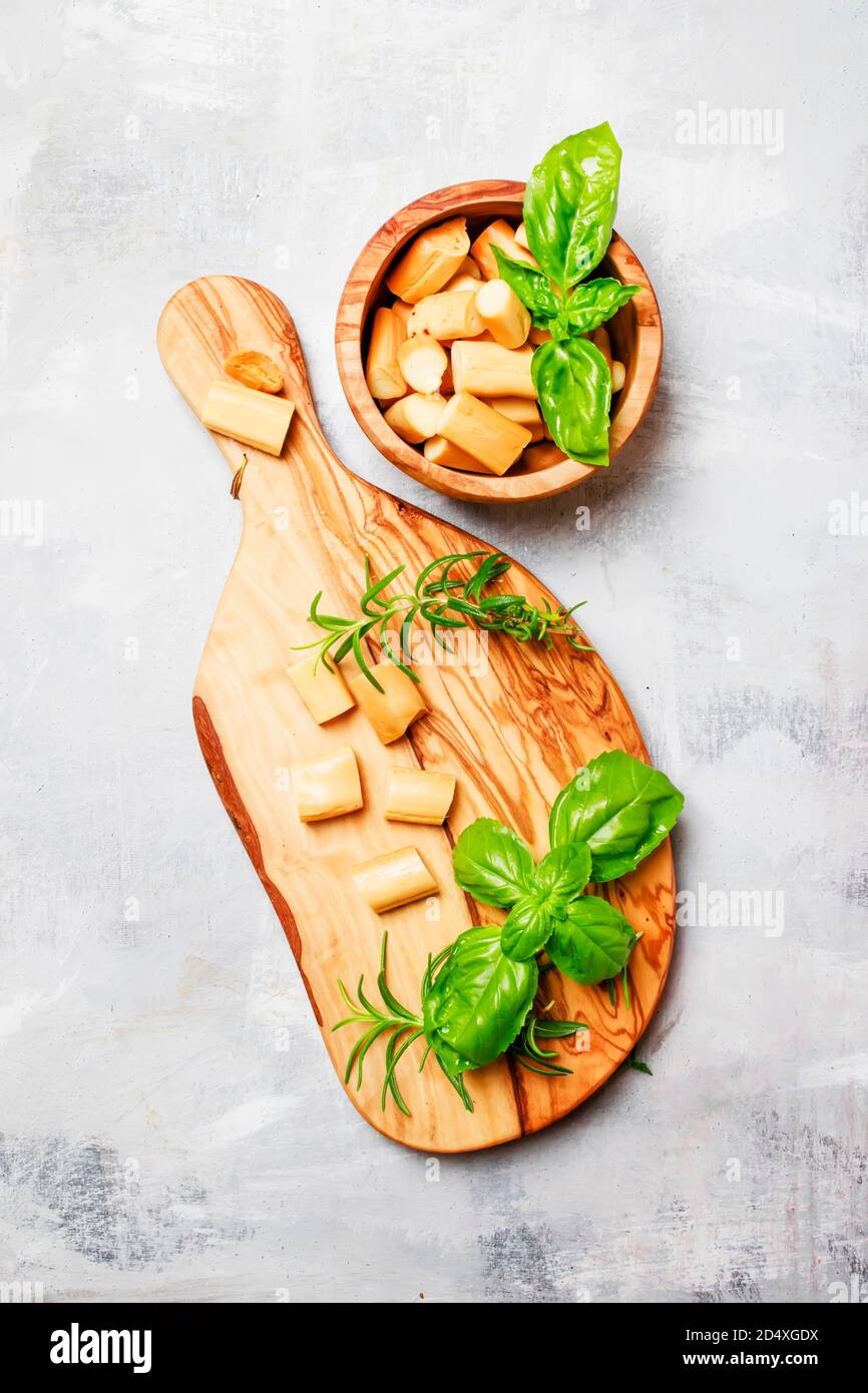 Traditional smoked Chechil cheese in bowl and cutting board, top view ...