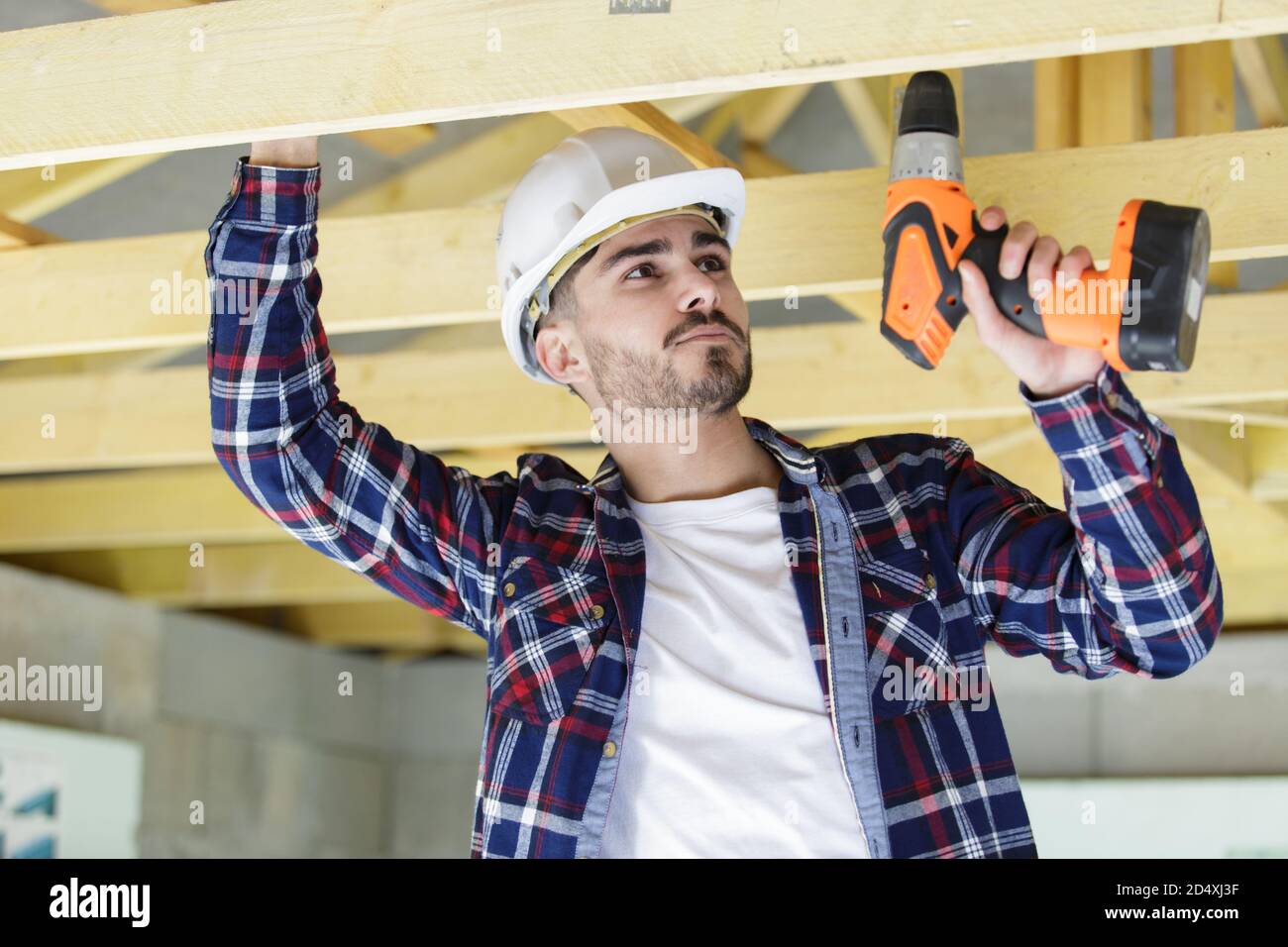 builder with helmet on the roof of a frame house Stock Photo - Alamy