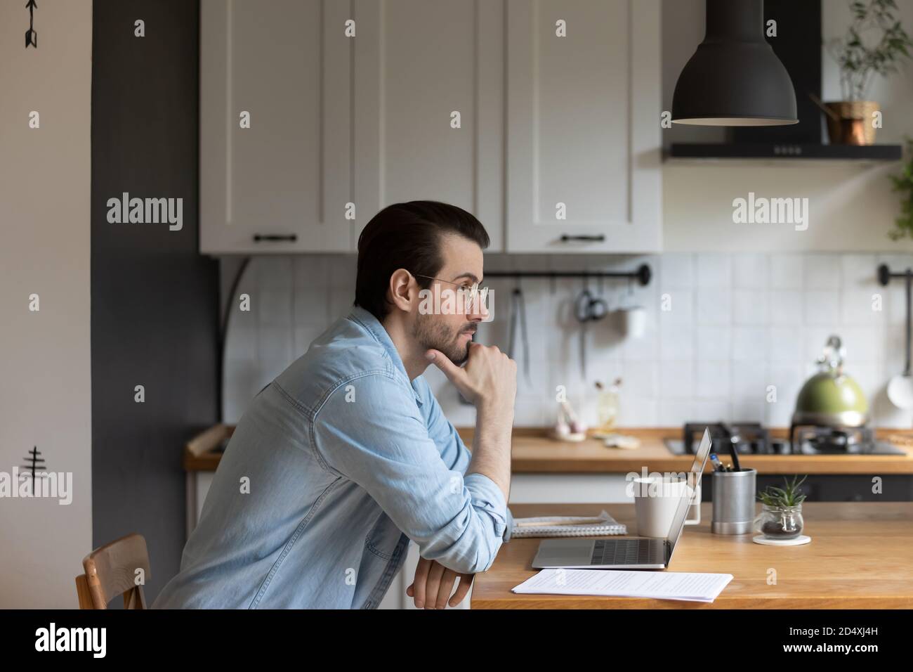 Distracted from computer work young man looking away Stock Photo - Alamy
