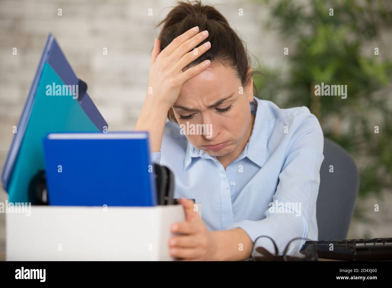 sad fired businesswoman holding box with her stuff Stock Photo - Alamy