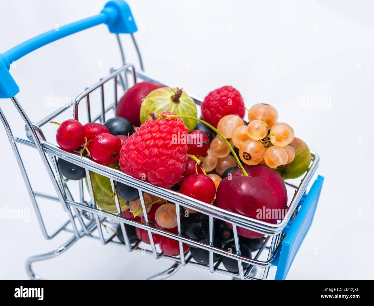 Mini grocery cart filled with fresh vitamin berries isolated on white ...