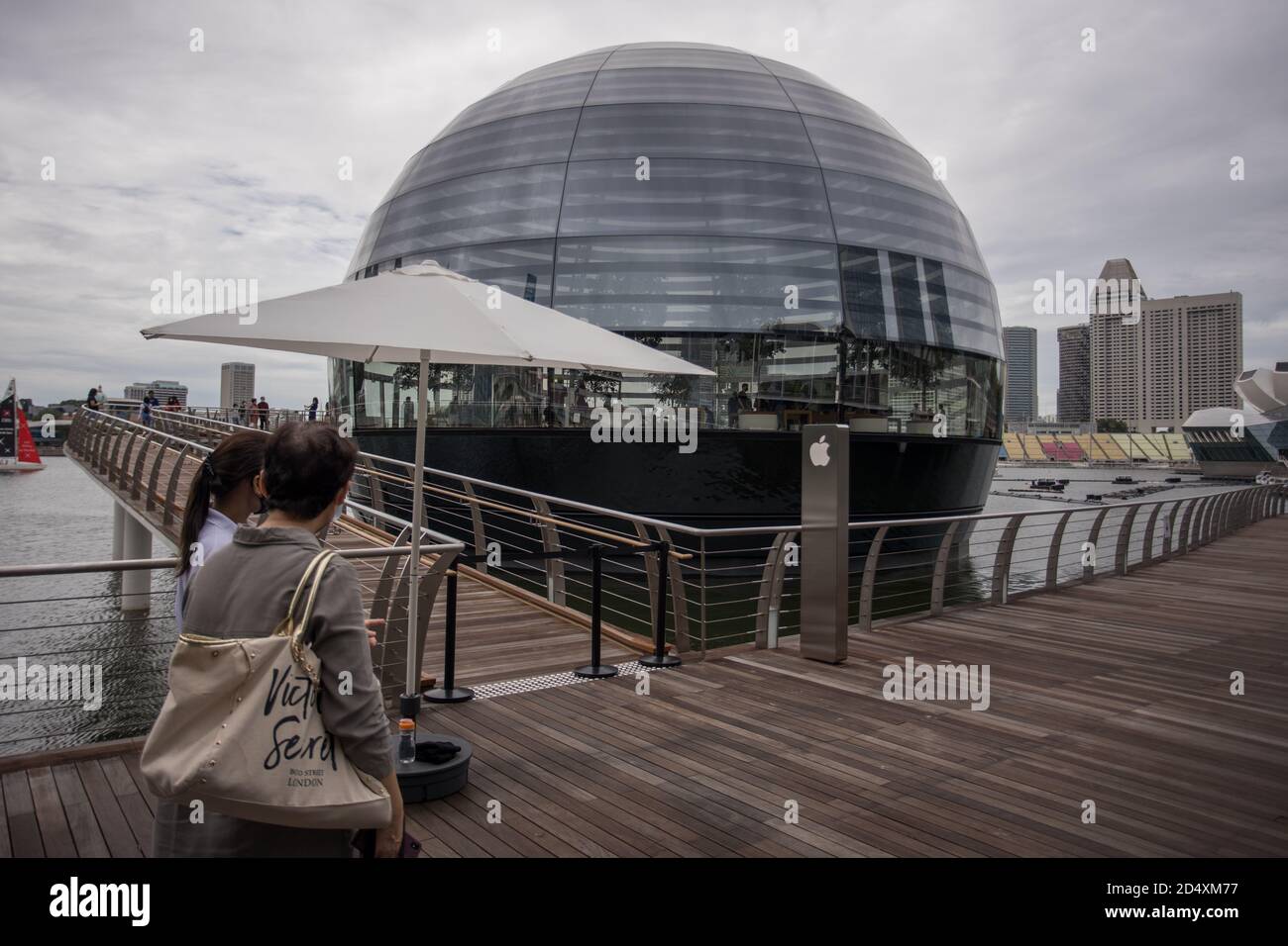 People walking along the Apple store at Marina Bay Sands.In a shape of ...