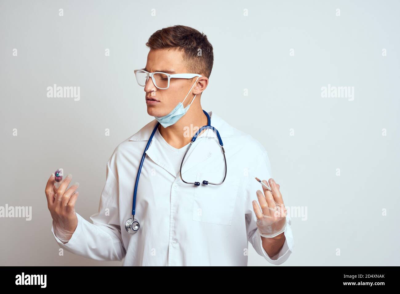 doctor in a medical gown with a stethoscope and glasses on a light ...