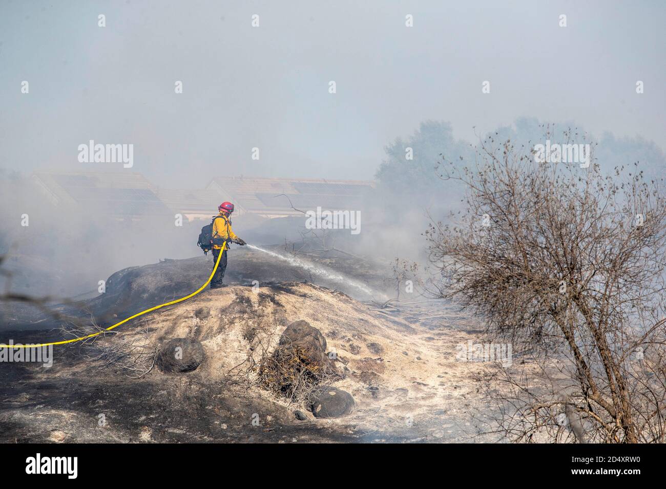 A firefighter with the Camp Pendleton Fire Department works to put out ...