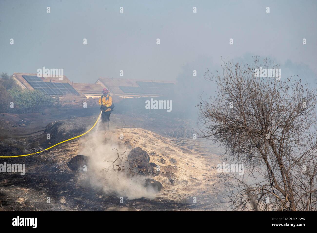 A firefighter with the Camp Pendleton Fire Department works to put out ...