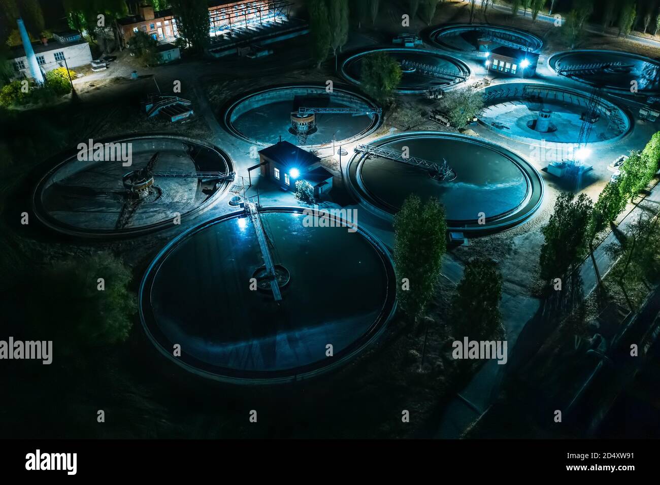 Aerial night view of modern wastewater treatment plant with round pools ...