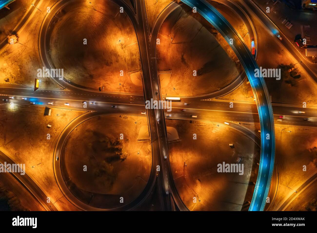 Large roundabout or road transport junction at night with car traffic ...