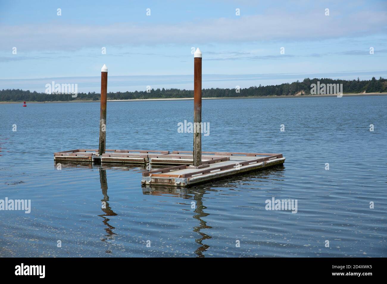 Small L shaped floating boat dock with two columns topped by white caps ...