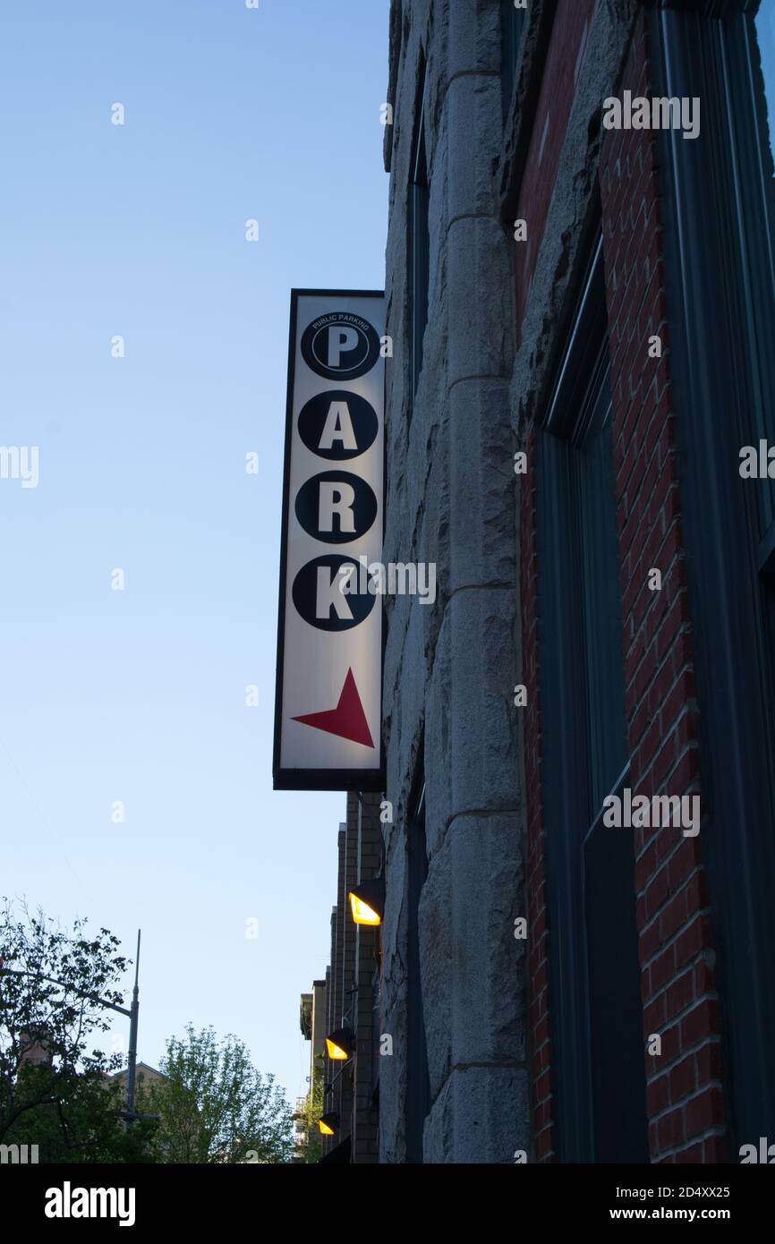 Modern looking public parking sign attached to a wall of the building ...