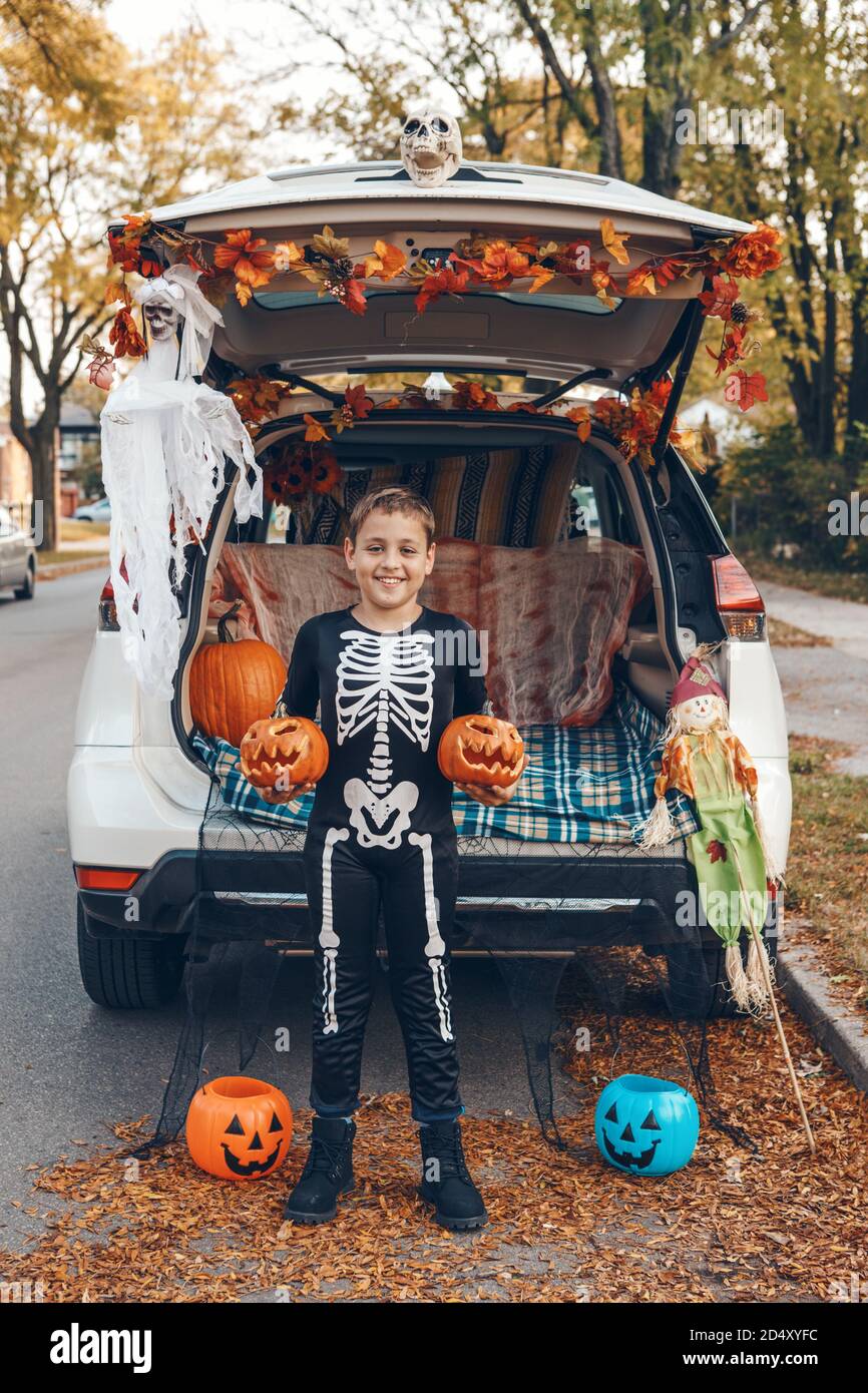 Trick or trunk. Boy child with red carved pumpkins celebrating ...