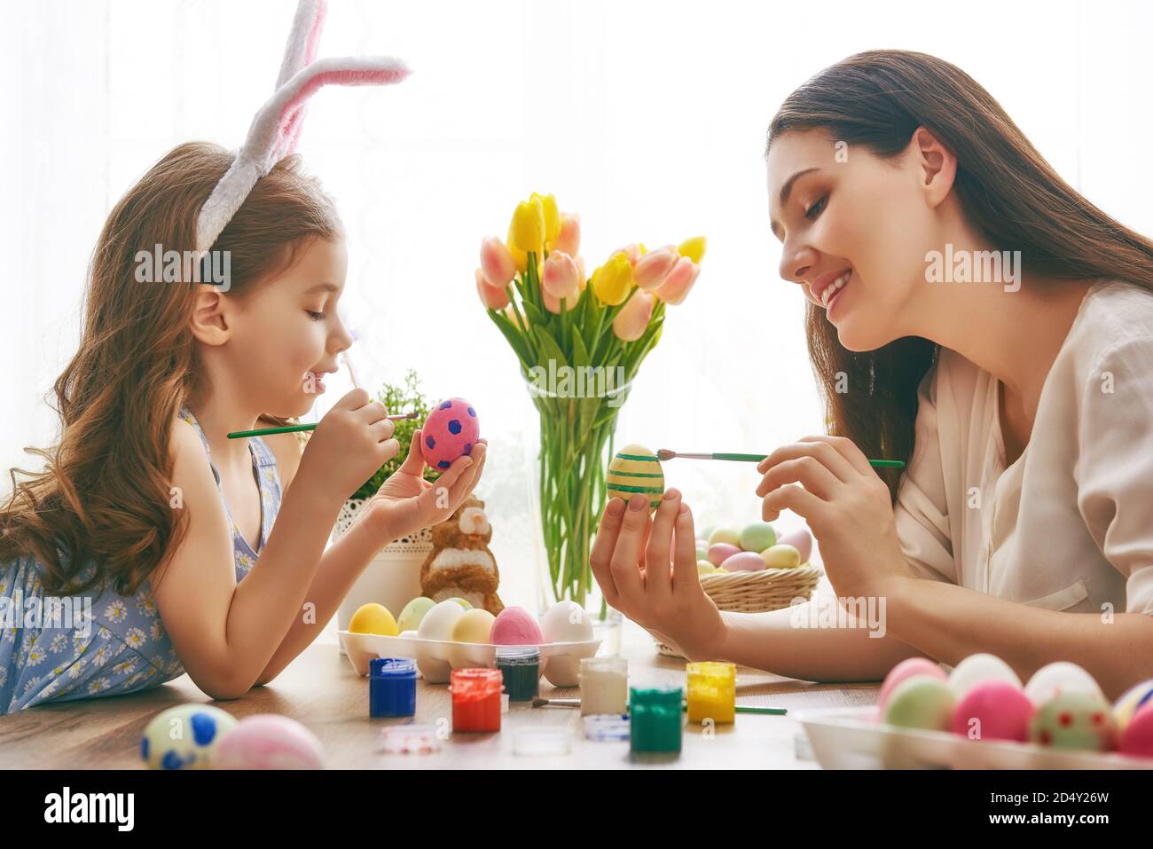 Happy easter! A mother and her daughter painting Easter eggs. Happy ...