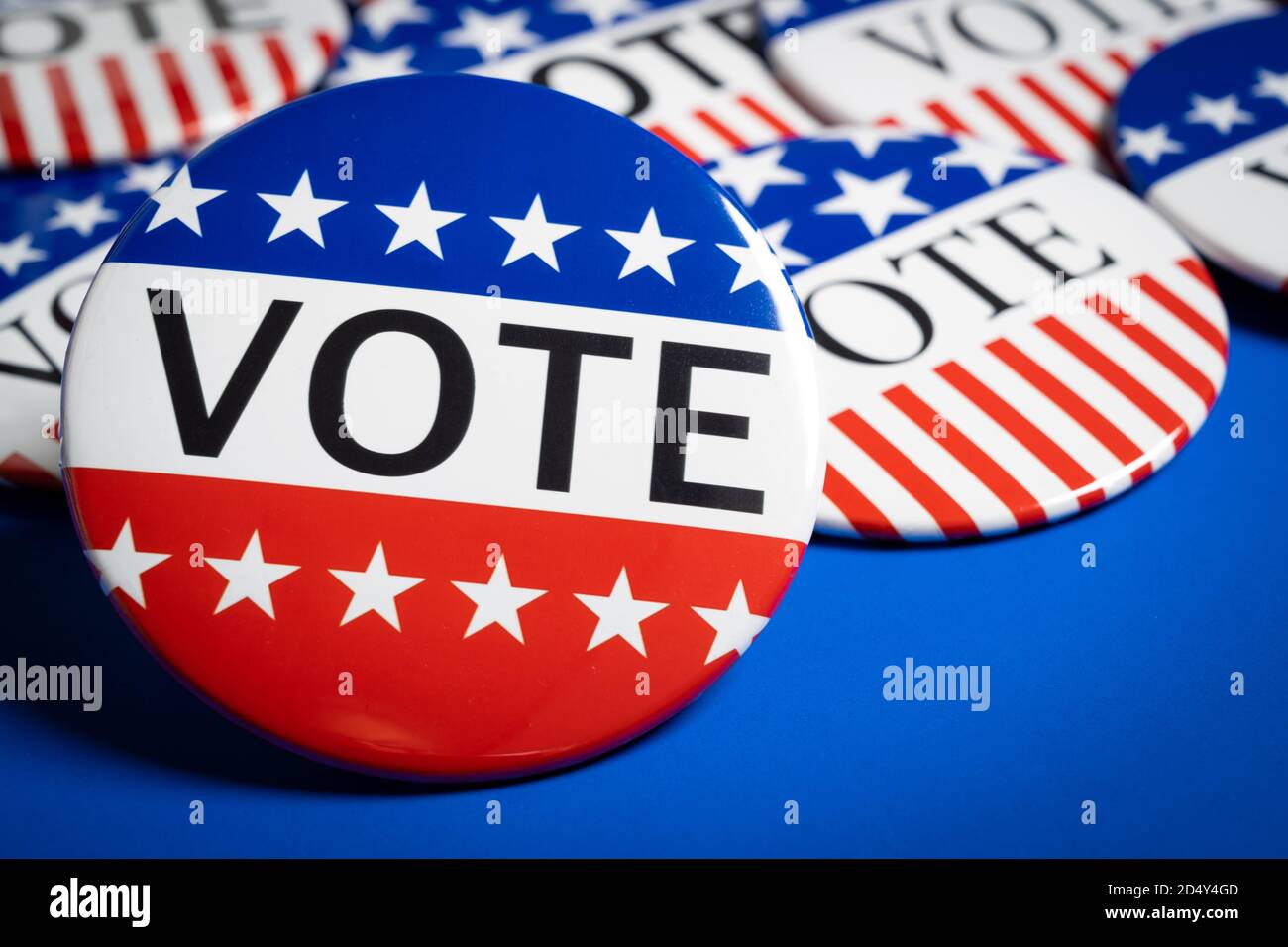 A group of red, white and blue VOTE button on a blue background Stock ...
