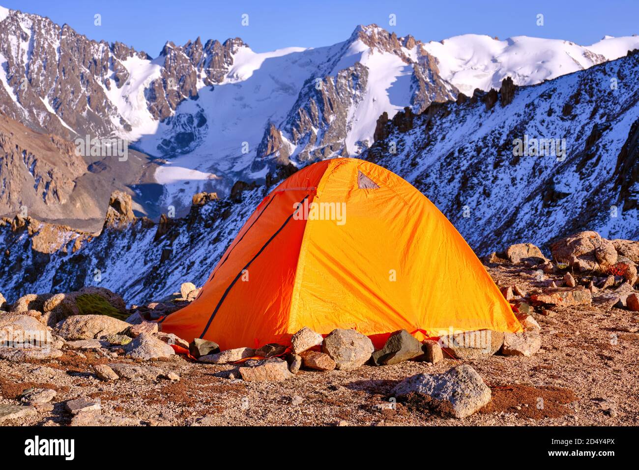 Tent is placed on a mountain ridge and reinforced with stones around ...