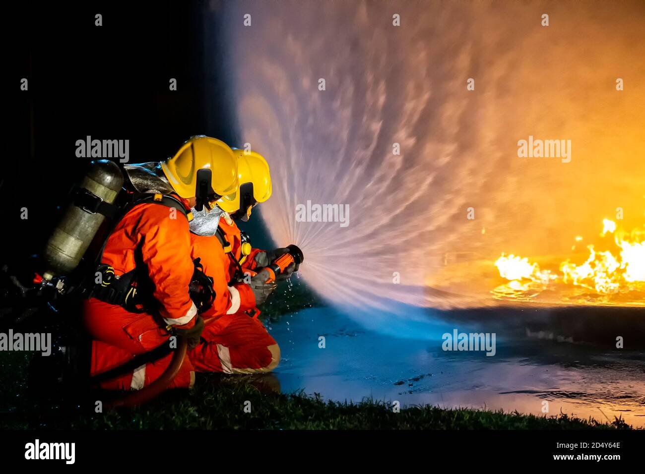 Firefighter training, fireman using water and extinguisher to fighting ...