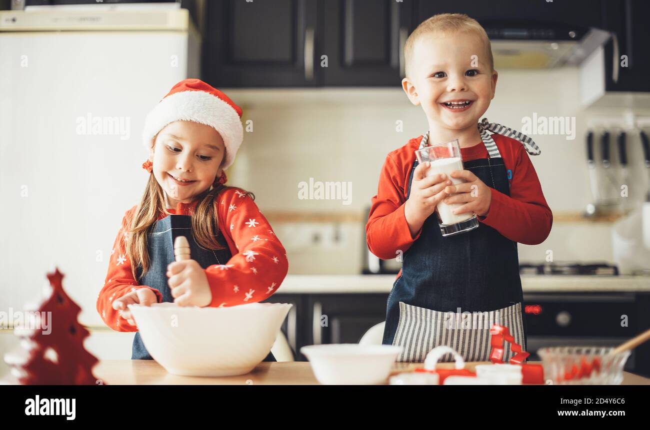 Happy bother and sister cooking something in the kitchen while prepare ...
