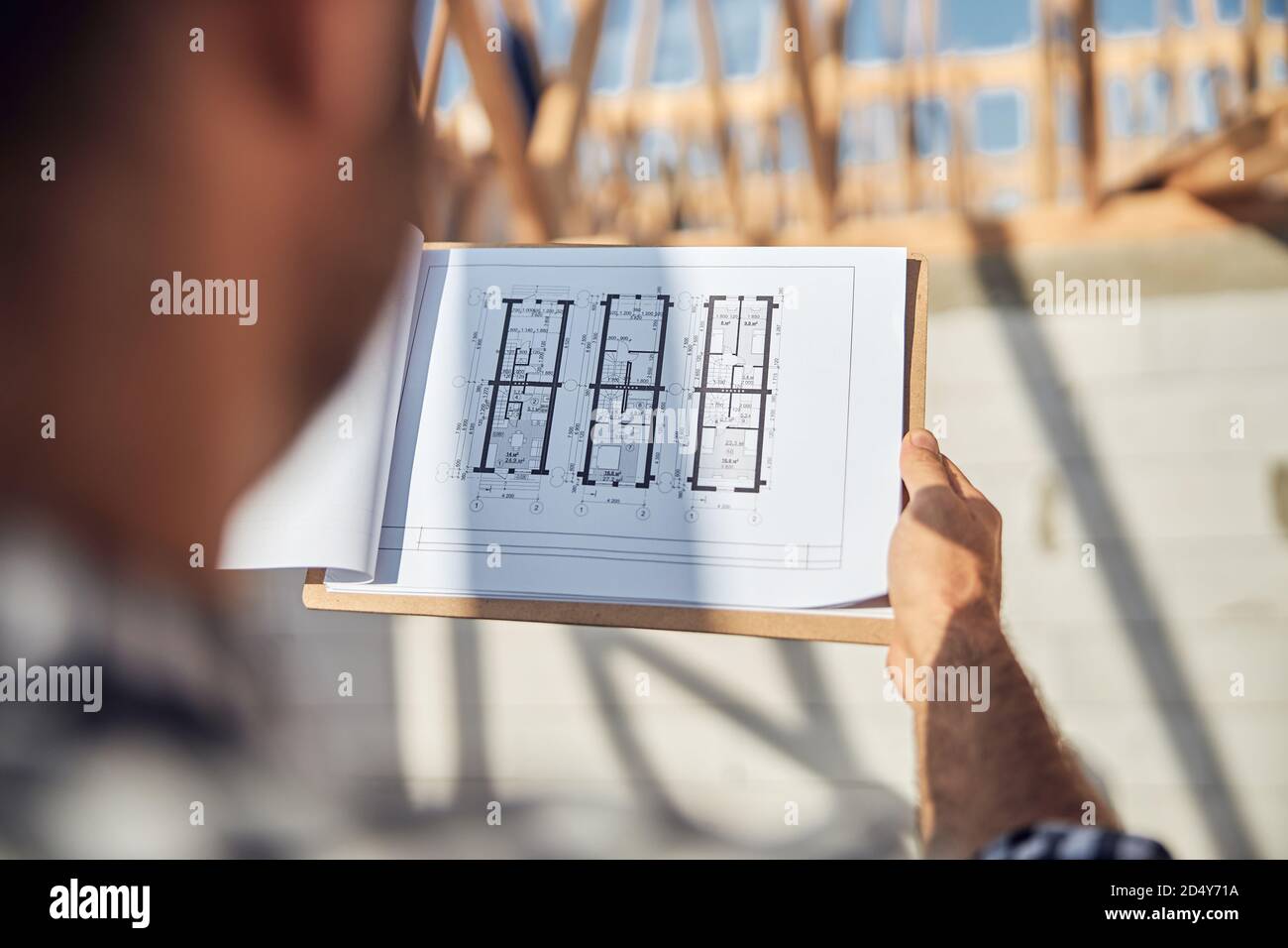 Experienced field engineer looking at schematic plan of a building ...