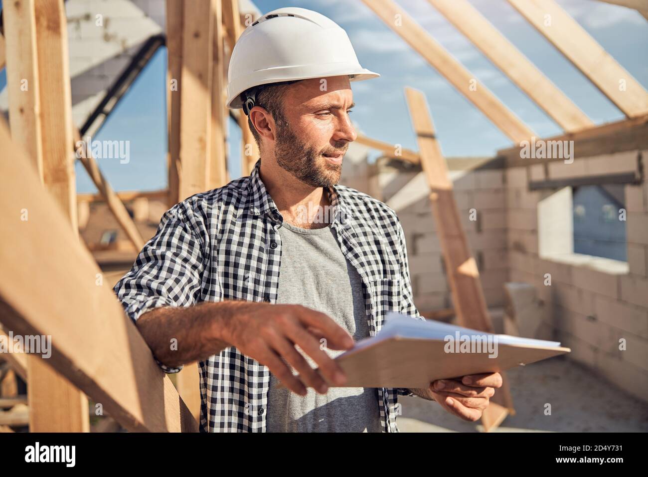Focused field engineer checking his building plan Stock Photo - Alamy