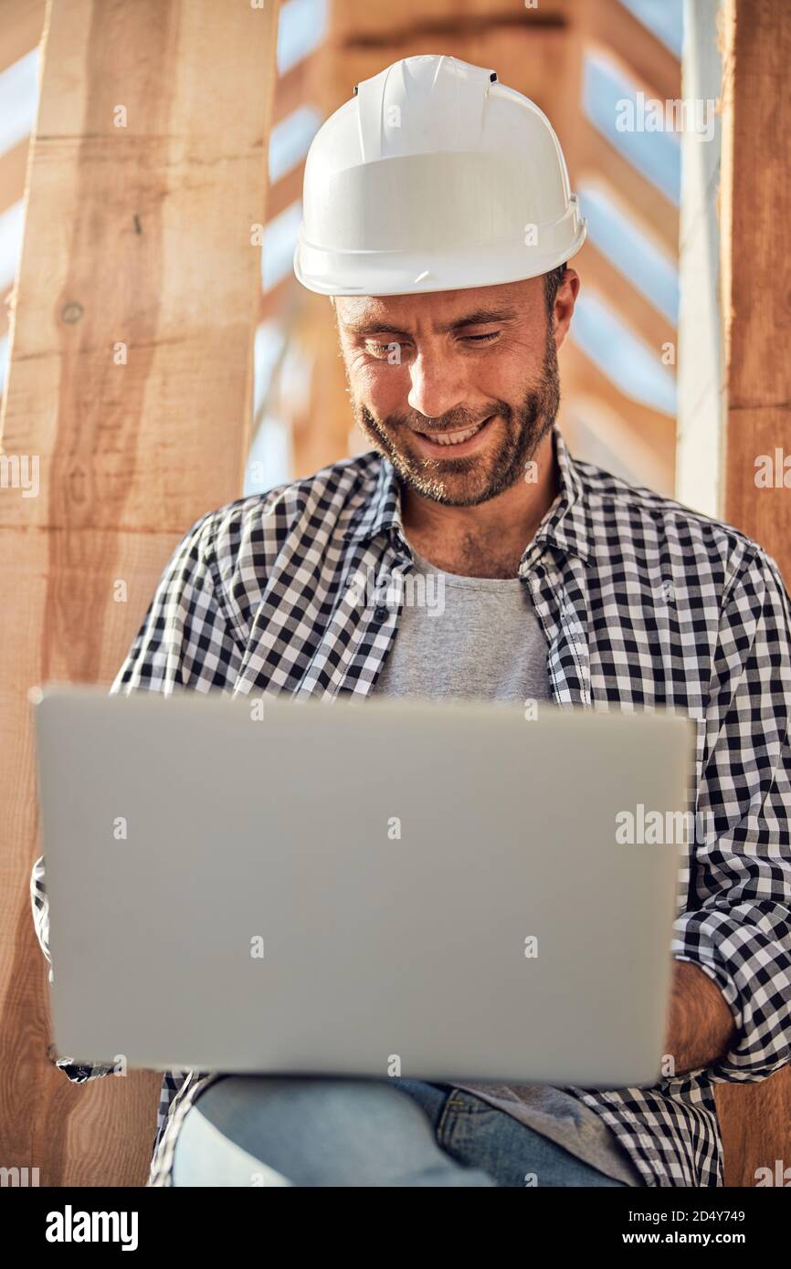 Joyous brunette field engineer working on his laptop Stock Photo - Alamy