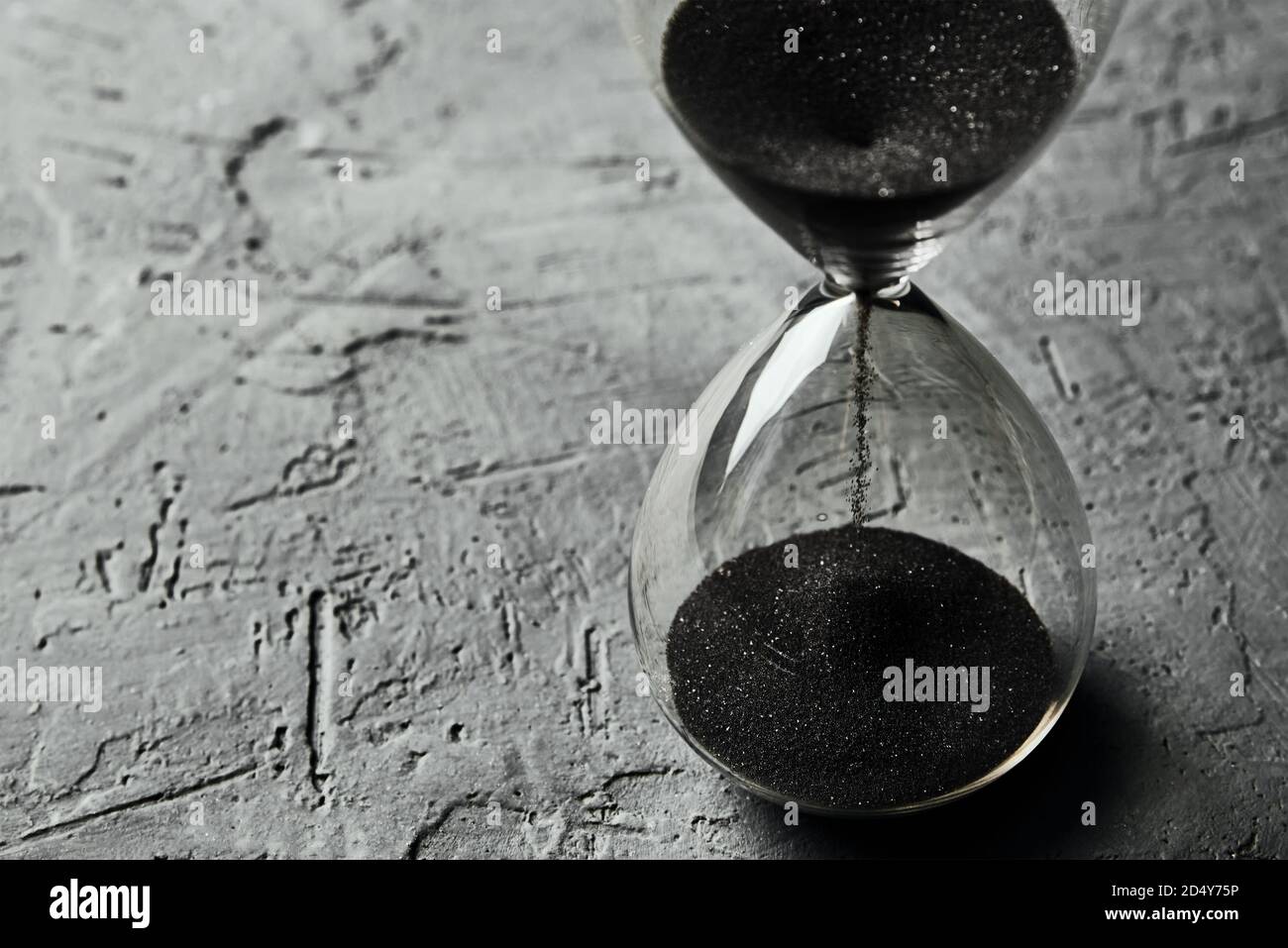 Hourglass on dark background, close up. Urgency and running out of time ...