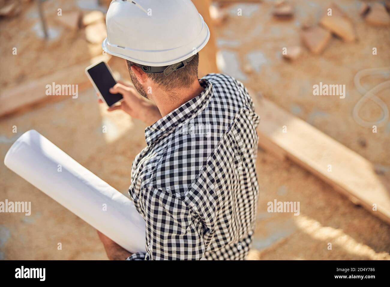 Busy architect with a roll of blueprints and a phone Stock Photo - Alamy