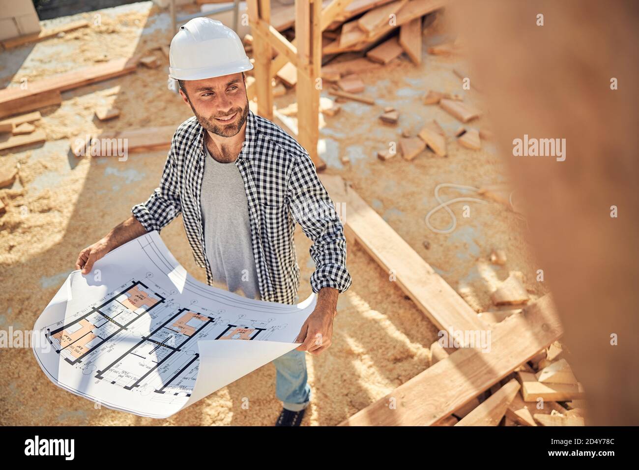 Qualified construction site worker with a blueprint of a house Stock ...