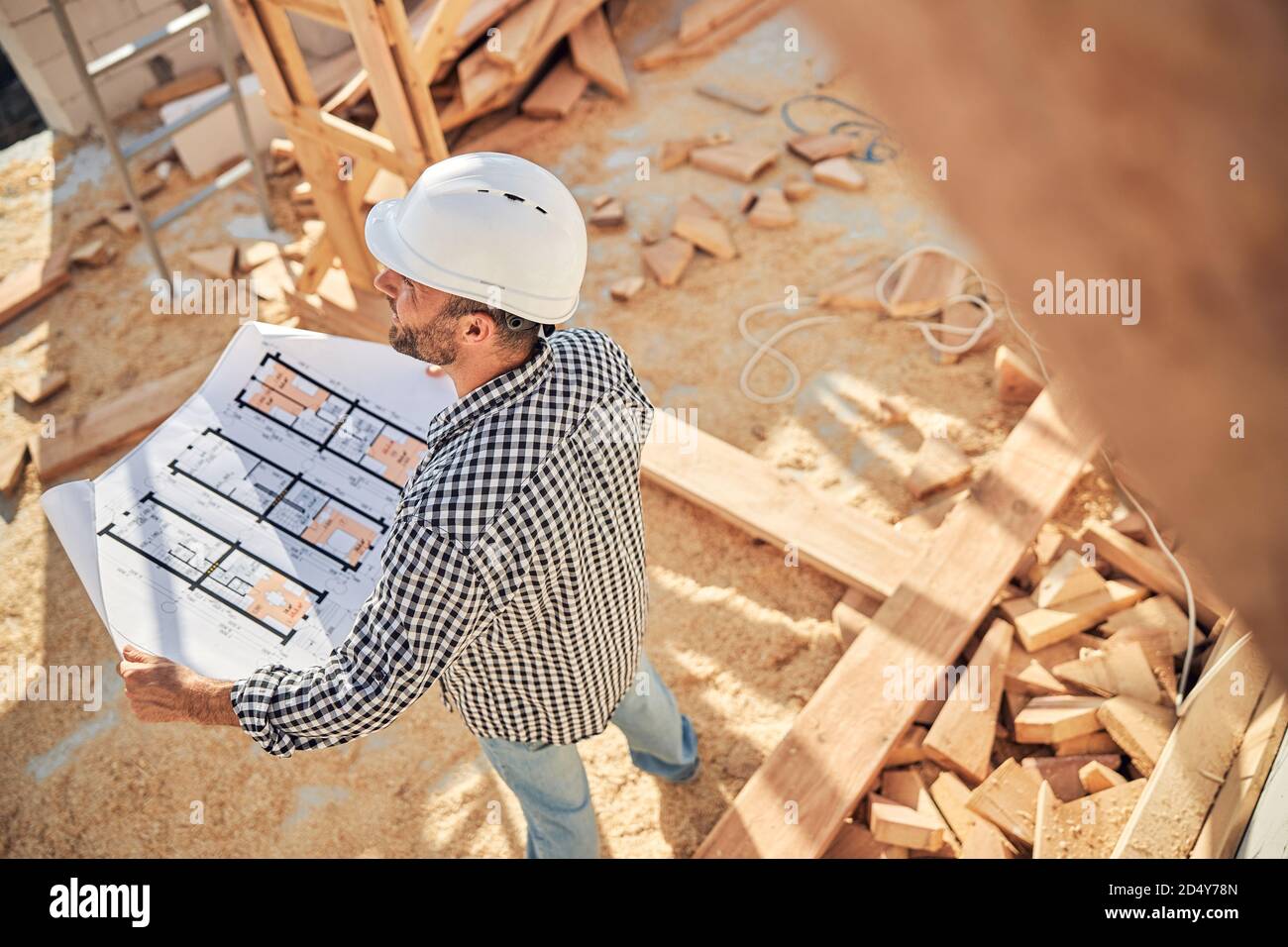 Committed builder checking blueprints of a house Stock Photo - Alamy
