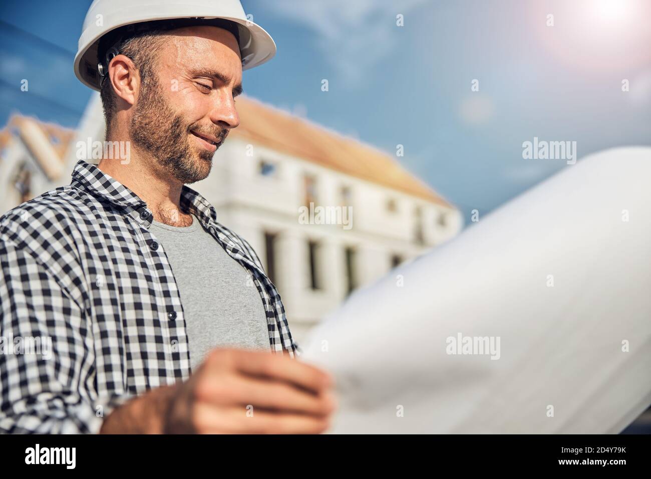 Gladsome man looking closely at a white sheet of paper Stock Photo - Alamy